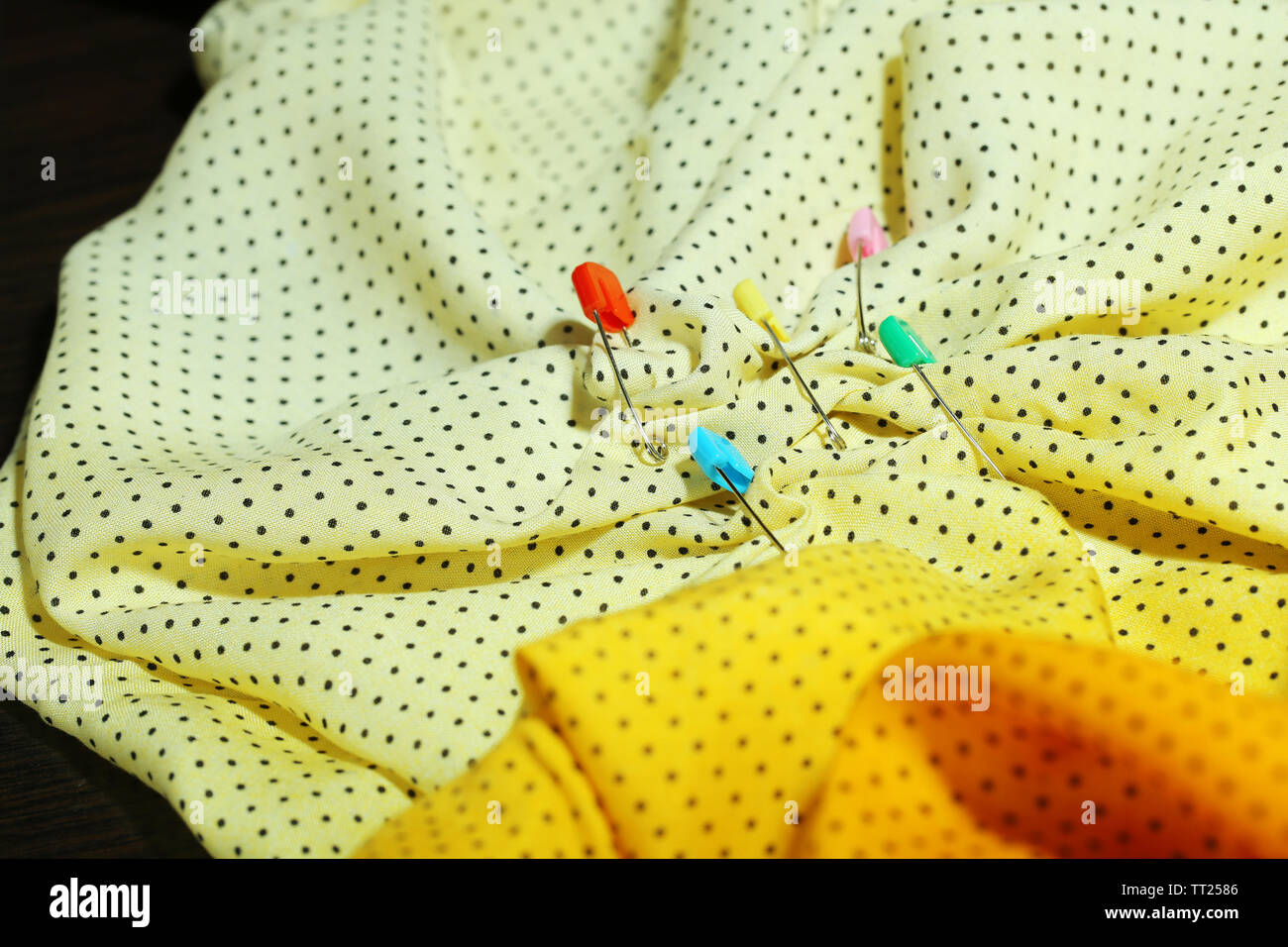 Safety pins on fabric background Stock Photo - Alamy