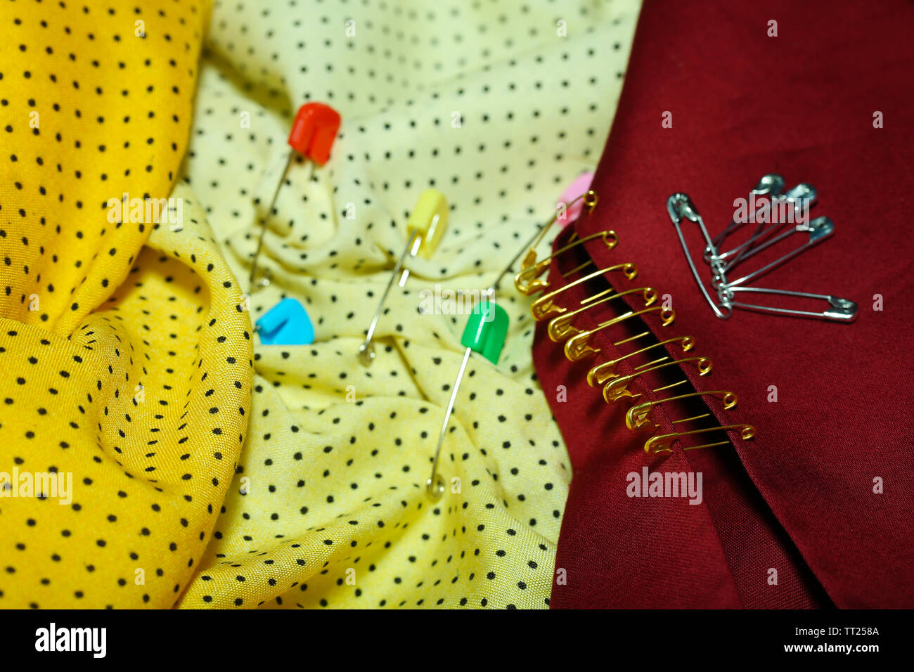 Safety pins on fabric background Stock Photo - Alamy