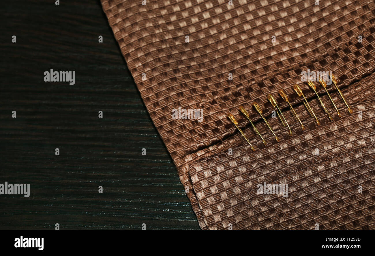 Safety pins on fabric background Stock Photo - Alamy