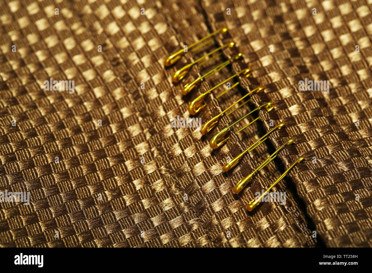 Safety pins on fabric background Stock Photo - Alamy
