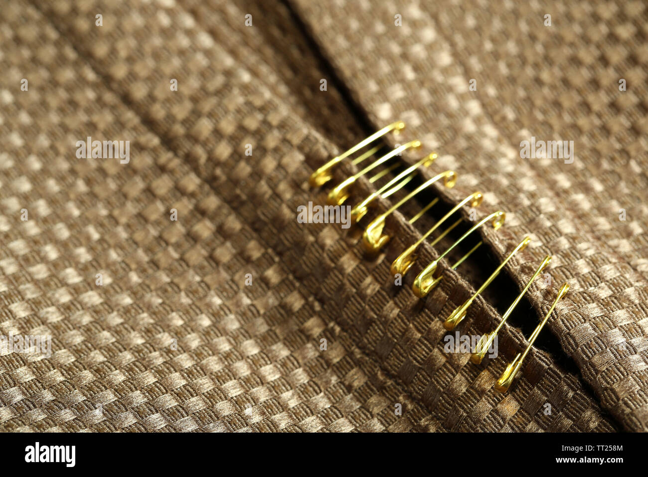 Safety pins on fabric background Stock Photo - Alamy