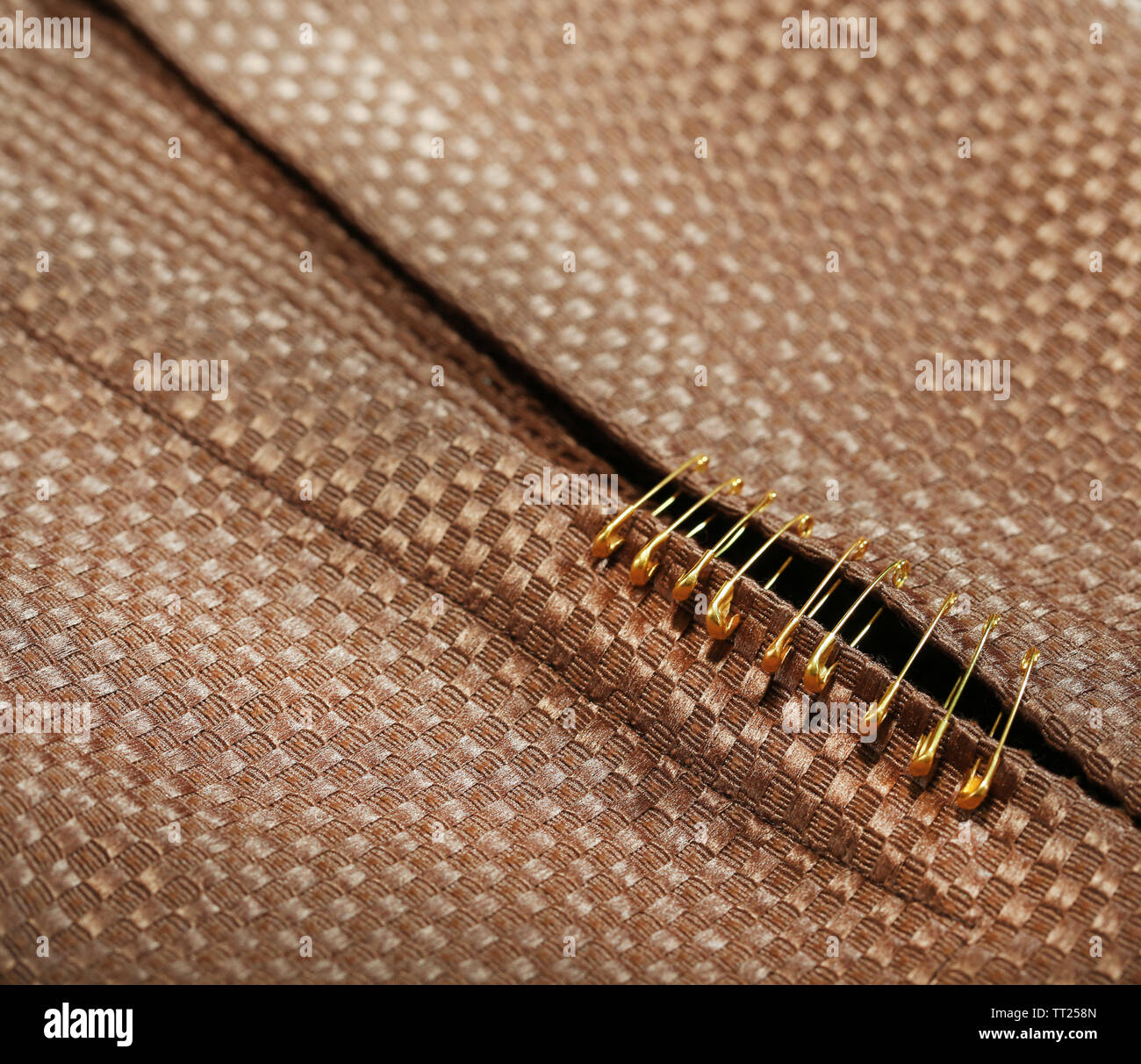 Safety pins on fabric background Stock Photo - Alamy