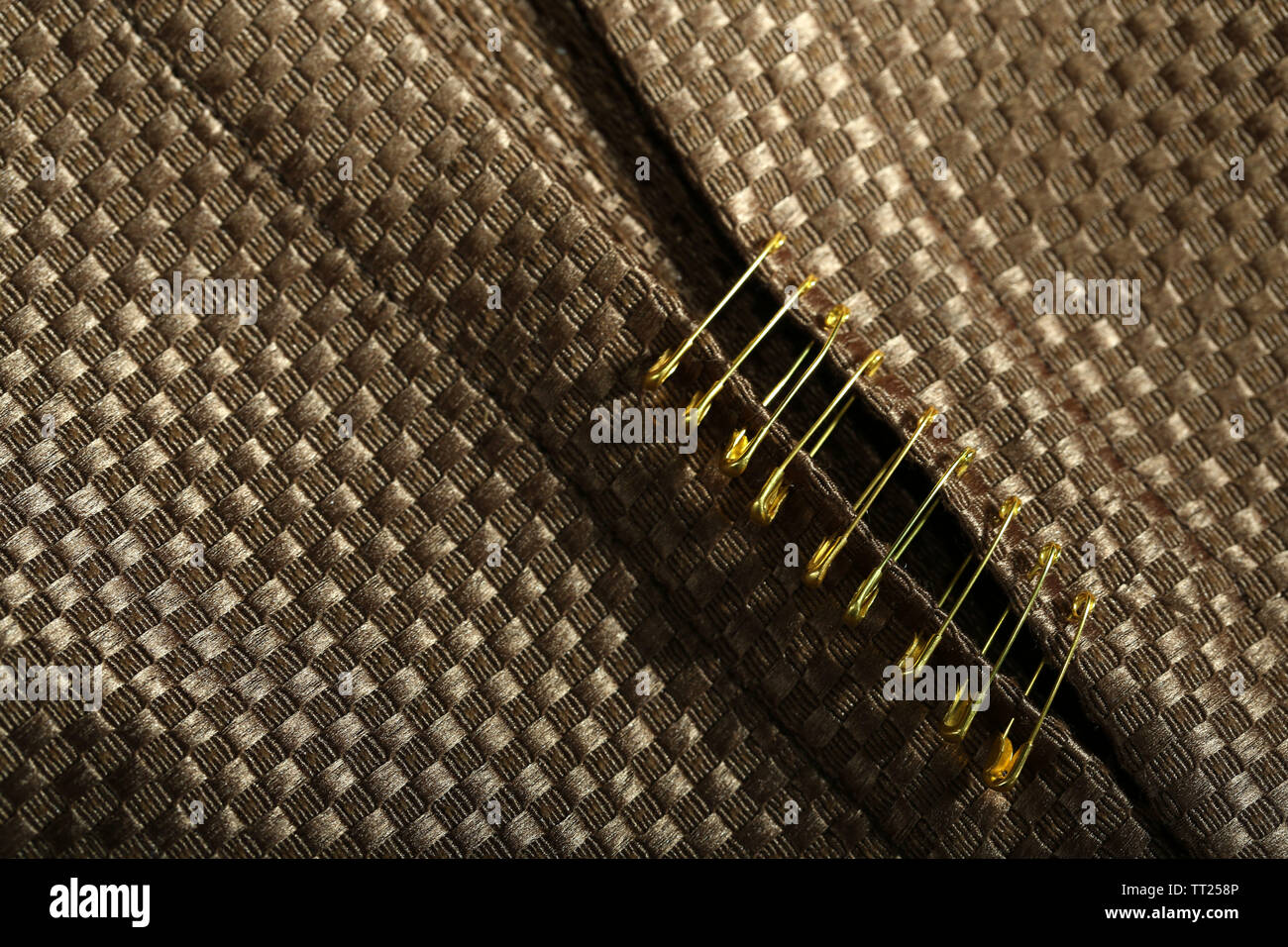 Safety pins on fabric background Stock Photo - Alamy