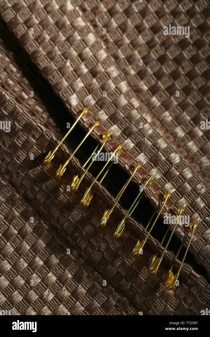 Safety pins on fabric background Stock Photo - Alamy