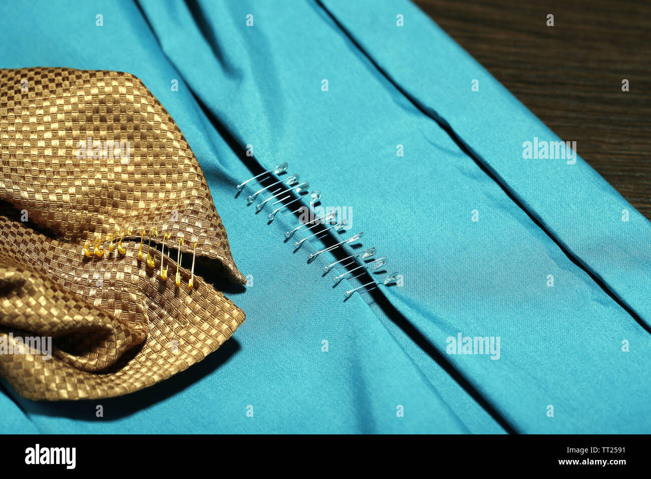 Safety pins on fabric background Stock Photo - Alamy