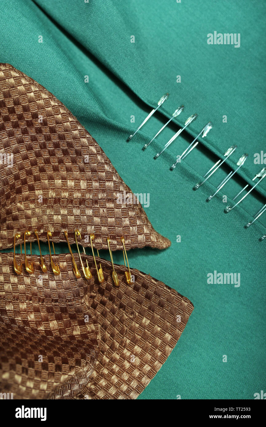 Safety pins on fabric background Stock Photo - Alamy