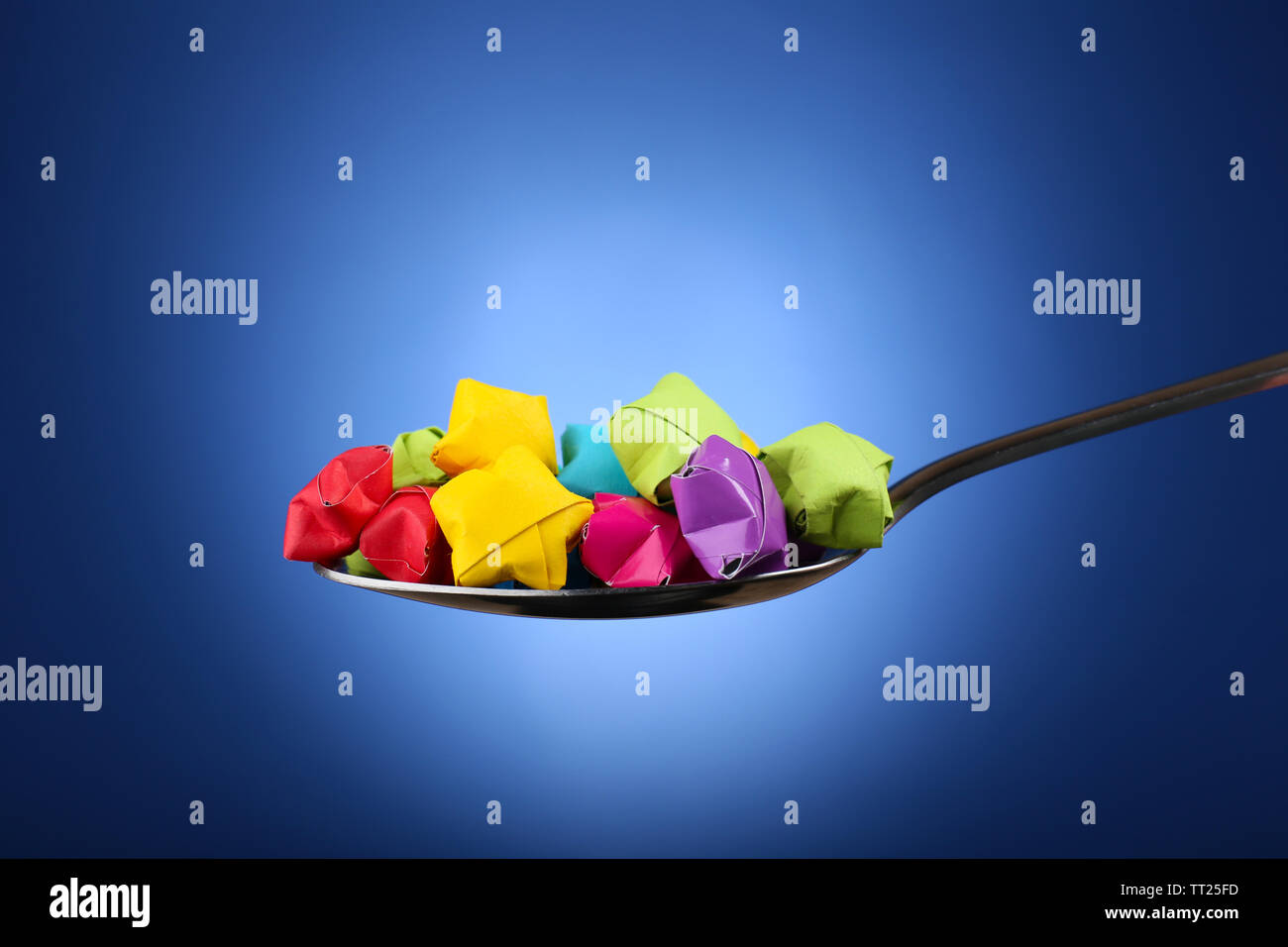 Paper stars in silver spoon on blue background Stock Photo - Alamy