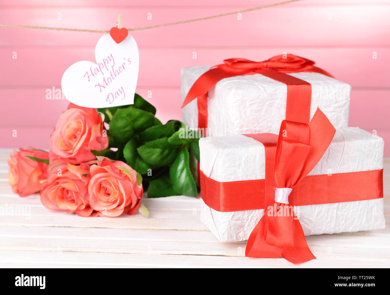 Happy Mothers Day message written on paper heart with flowers on pink ...