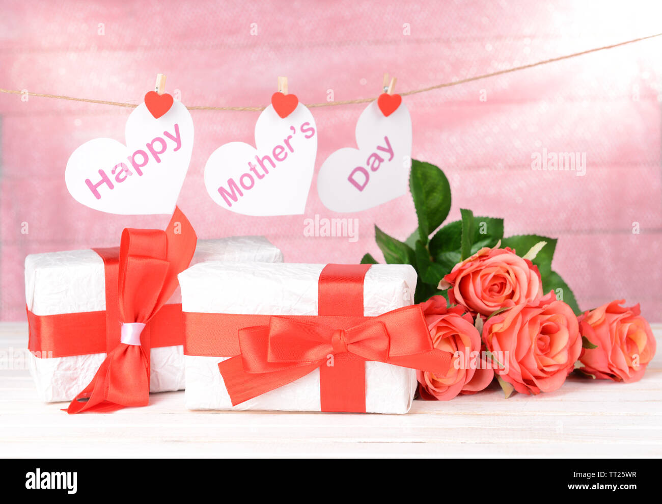 Happy Mothers Day message written on paper hearts with flowers on pink ...