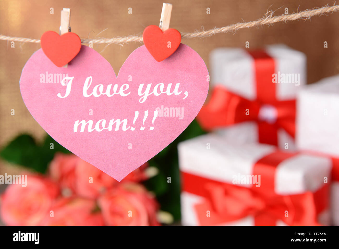 Happy Mothers Day message written on paper heart with flowers on brown ...