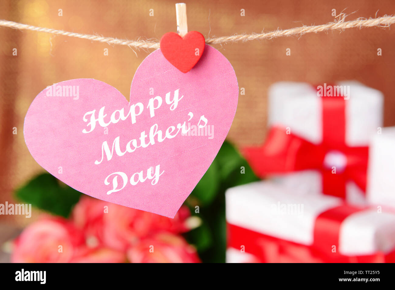 Happy Mothers Day message written on paper heart with flowers on brown ...