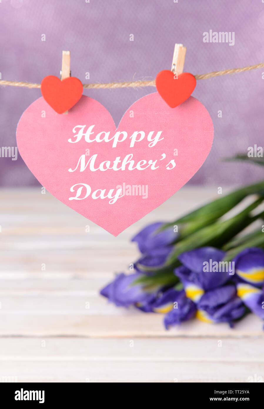 Happy Mothers Day message written on paper heart with flowers on purple ...