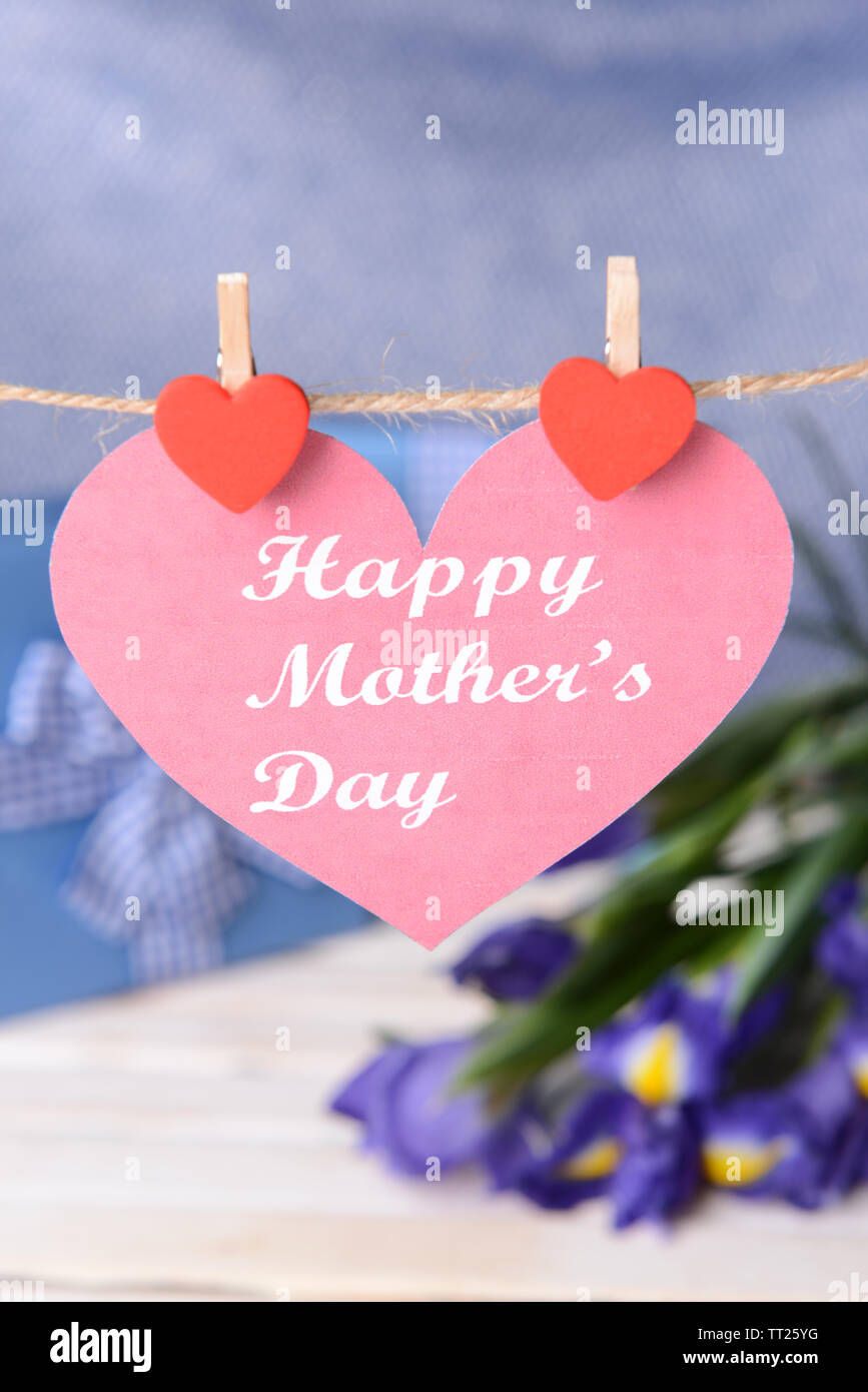 Happy Mothers Day message written on paper heart with flowers on purple ...