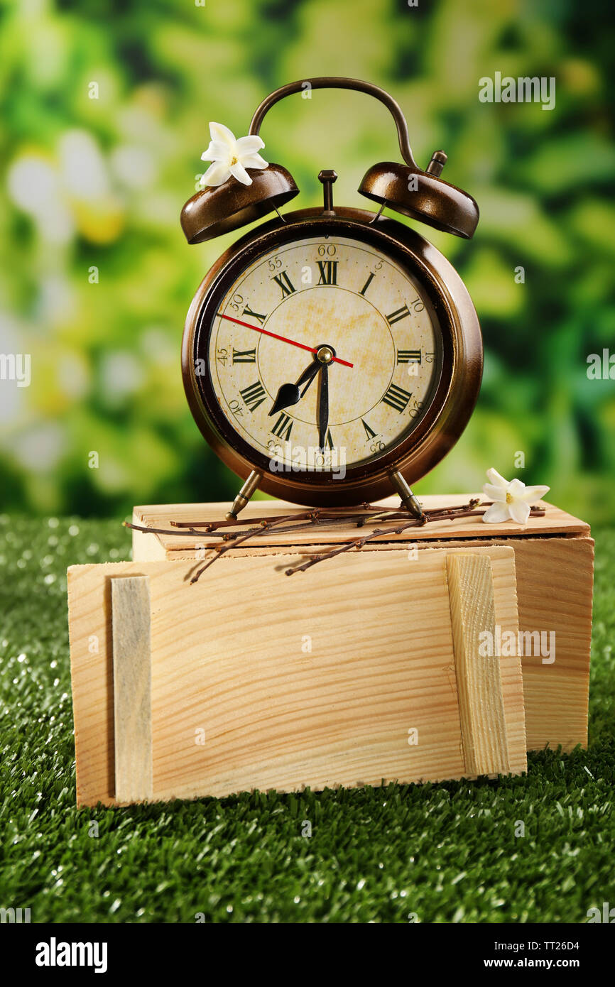 Alarm clock on green grass, on nature background Stock Photo - Alamy