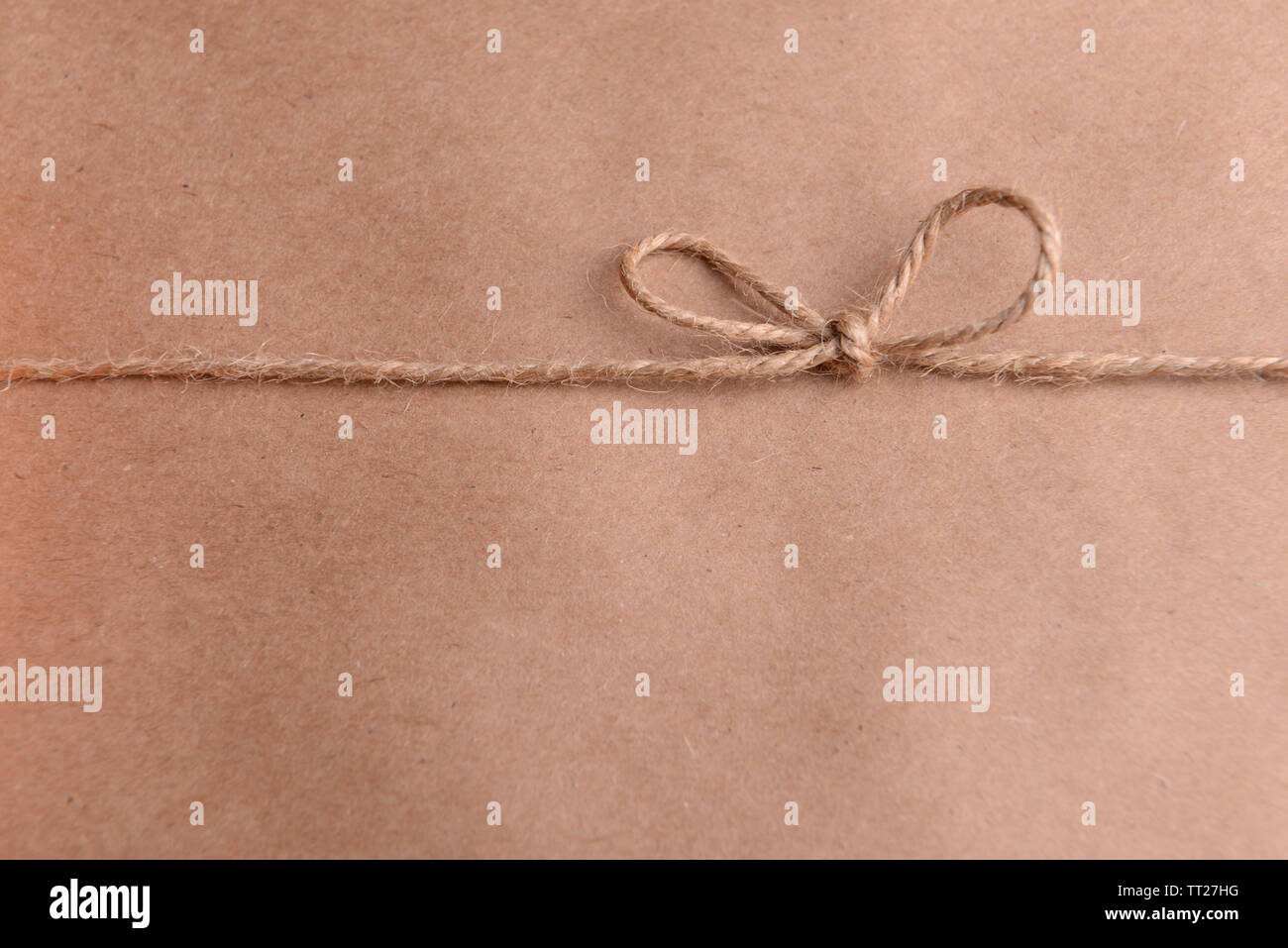String tied in bow on brown paper packaging close-up Stock Photo - Alamy
