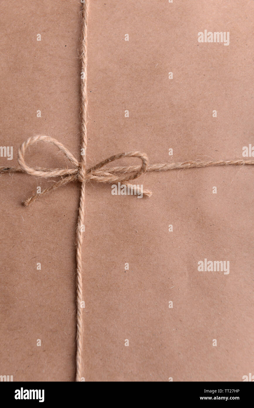 String tied in bow on brown paper packaging close-up Stock Photo - Alamy