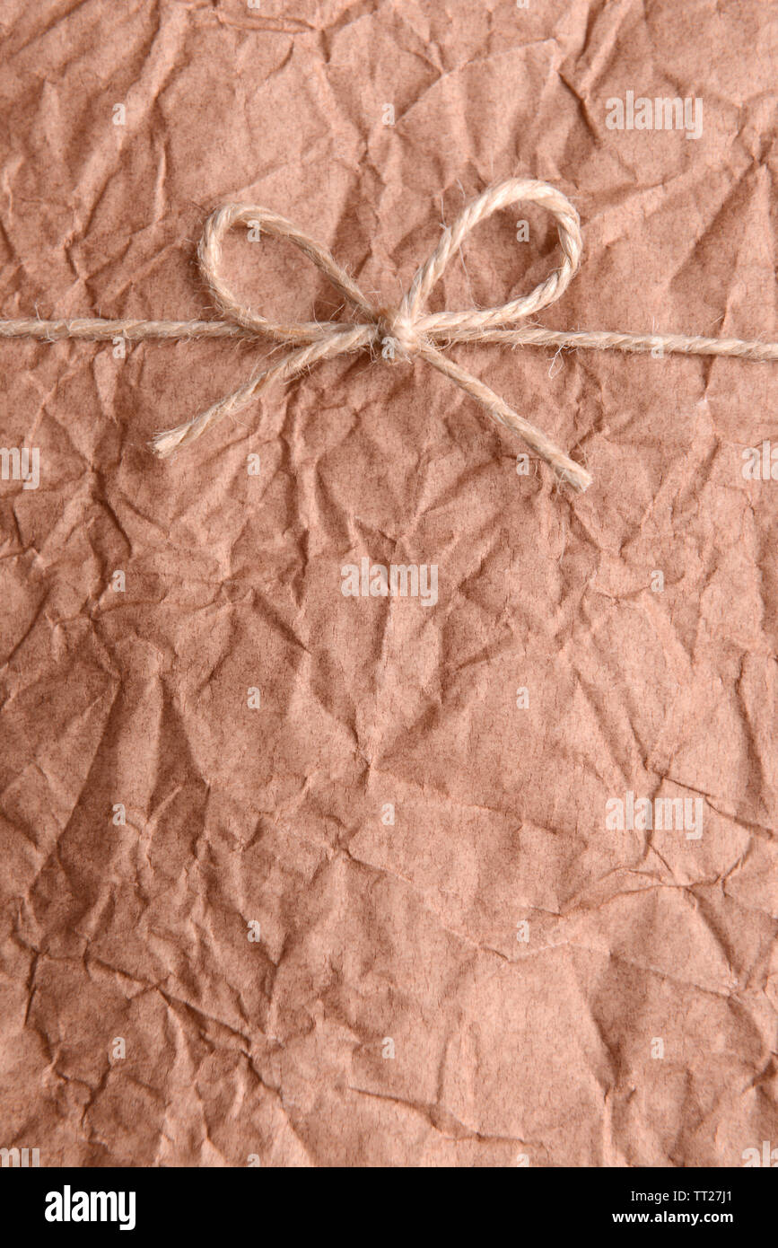 String tied in bow on brown paper packaging close-up Stock Photo - Alamy
