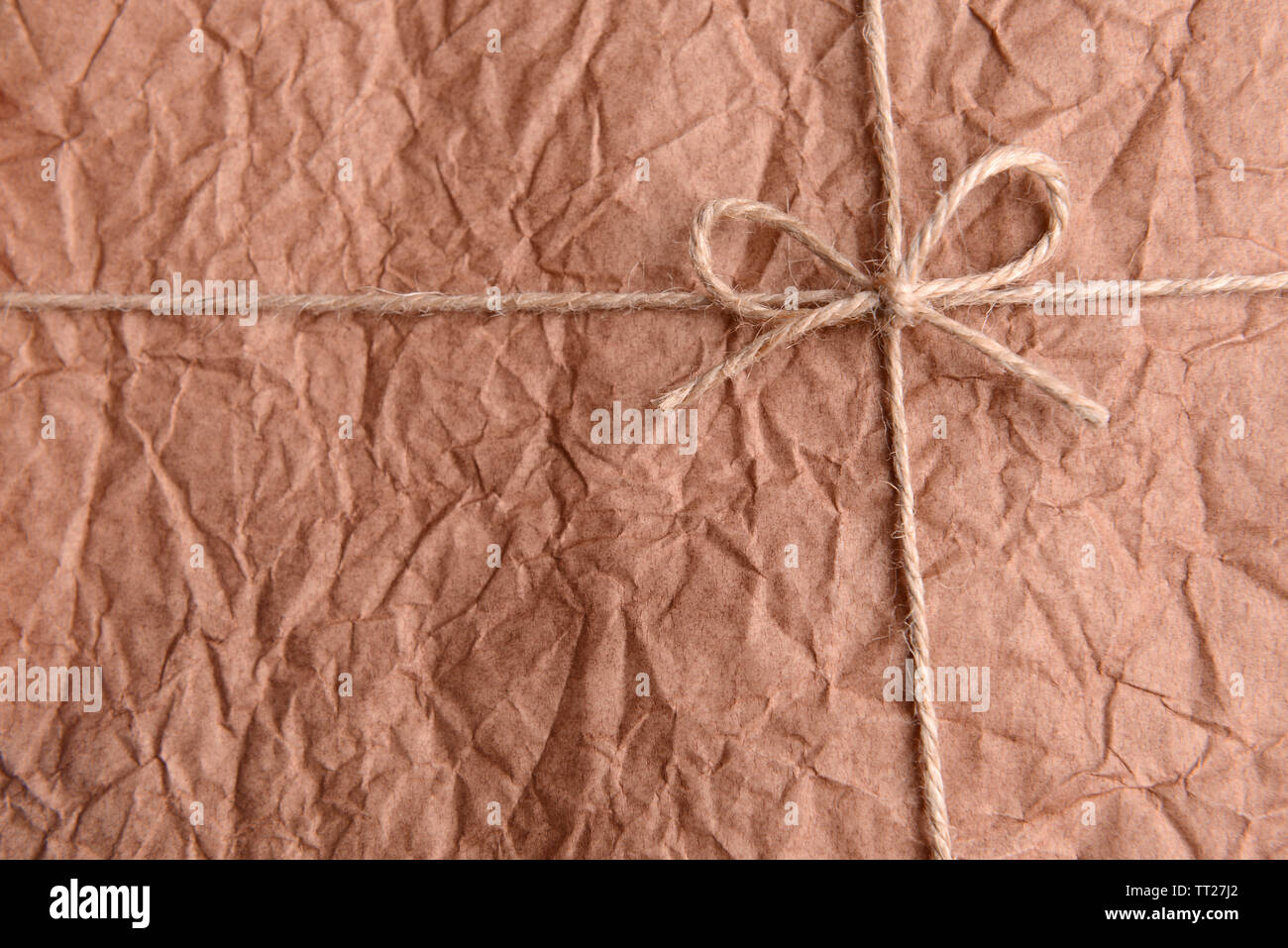 String tied in bow on brown paper packaging close-up Stock Photo - Alamy