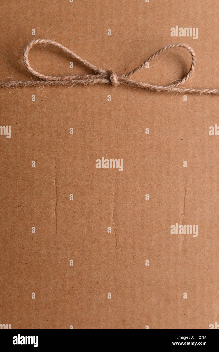 String tied in bow on brown paper packaging close-up Stock Photo - Alamy