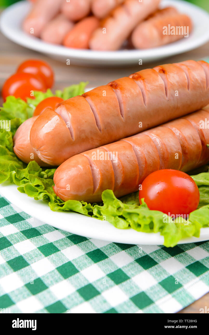 Grilled sausage on plate on table close-up Stock Photo - Alamy