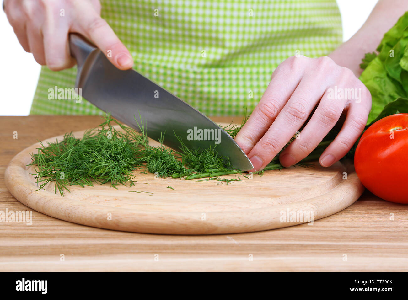 Female hands chopping dill on wooden board, close-up, isolated on white ...