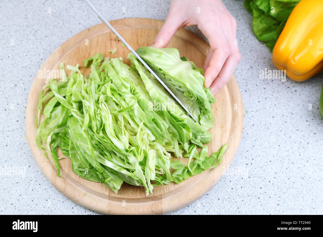 Female hands chopped cabbage on wooden board, close-up, on kitchen ...