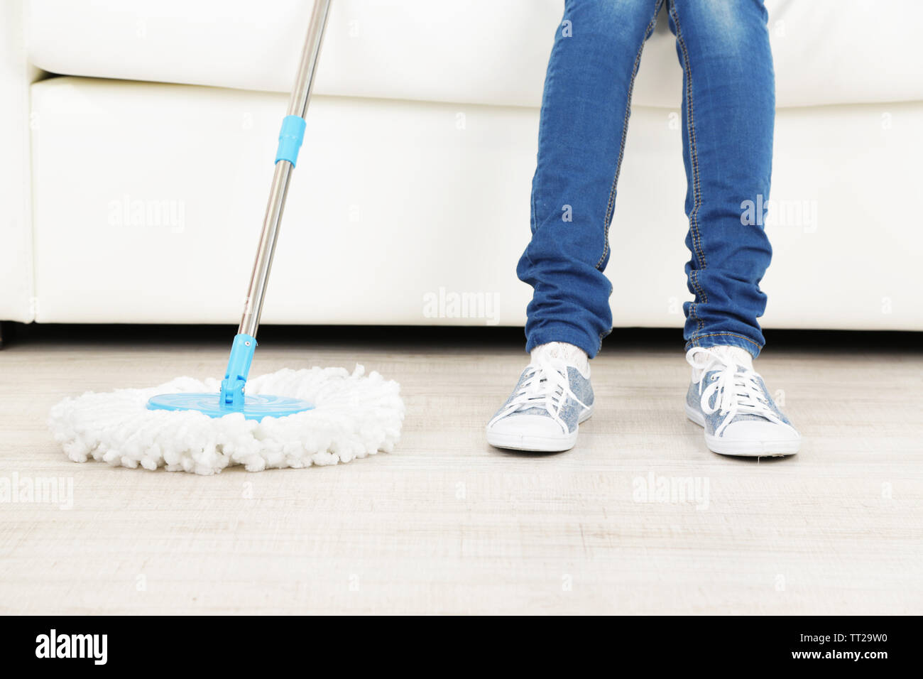 Woman resting on sofa after cleaning wooden floor from dust Stock Photo ...
