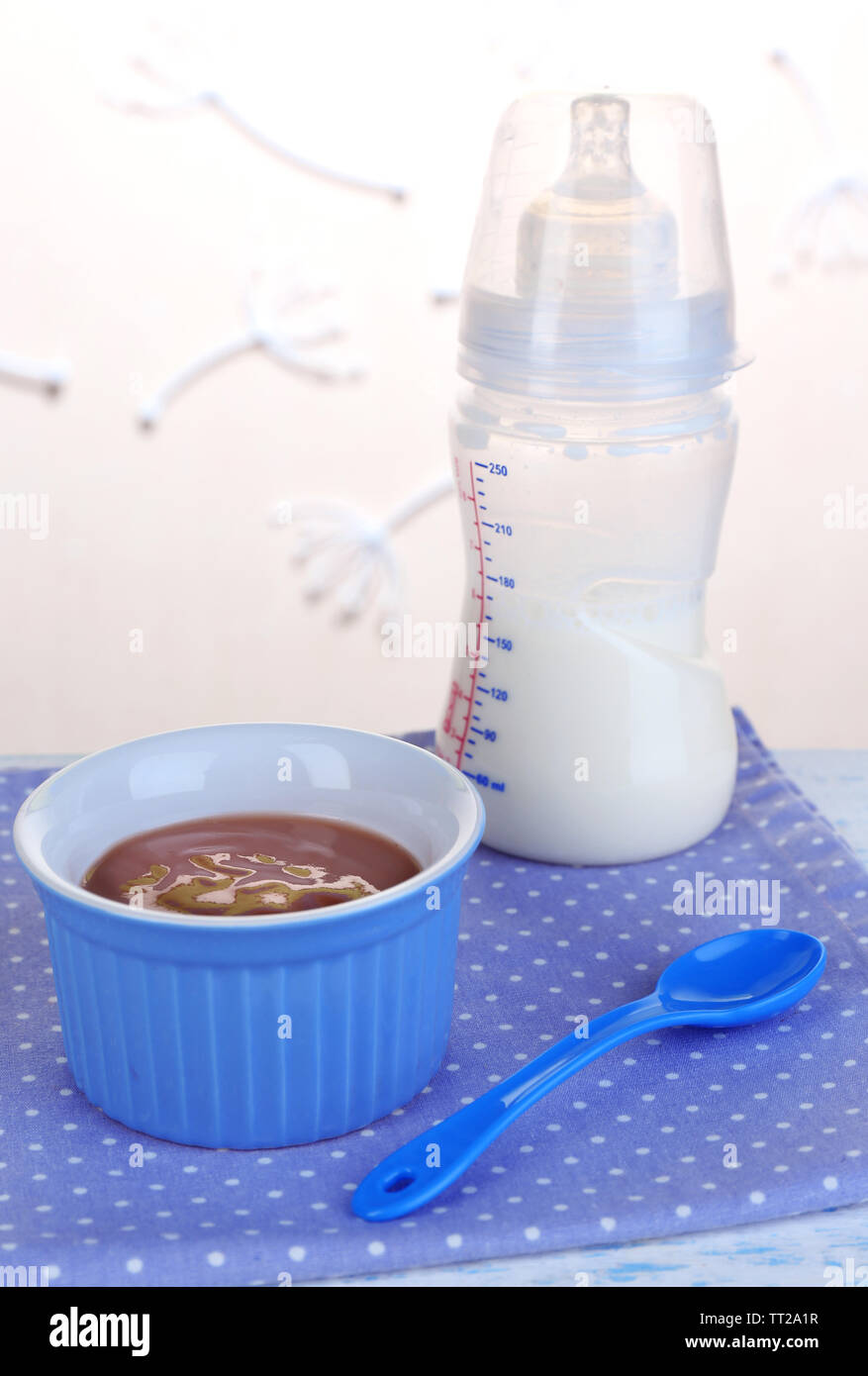 Baby food and milk on table on light background Stock Photo - Alamy