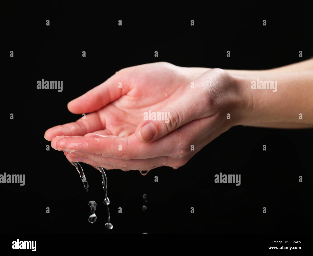 Human hands with water splashing on them on black background Stock ...