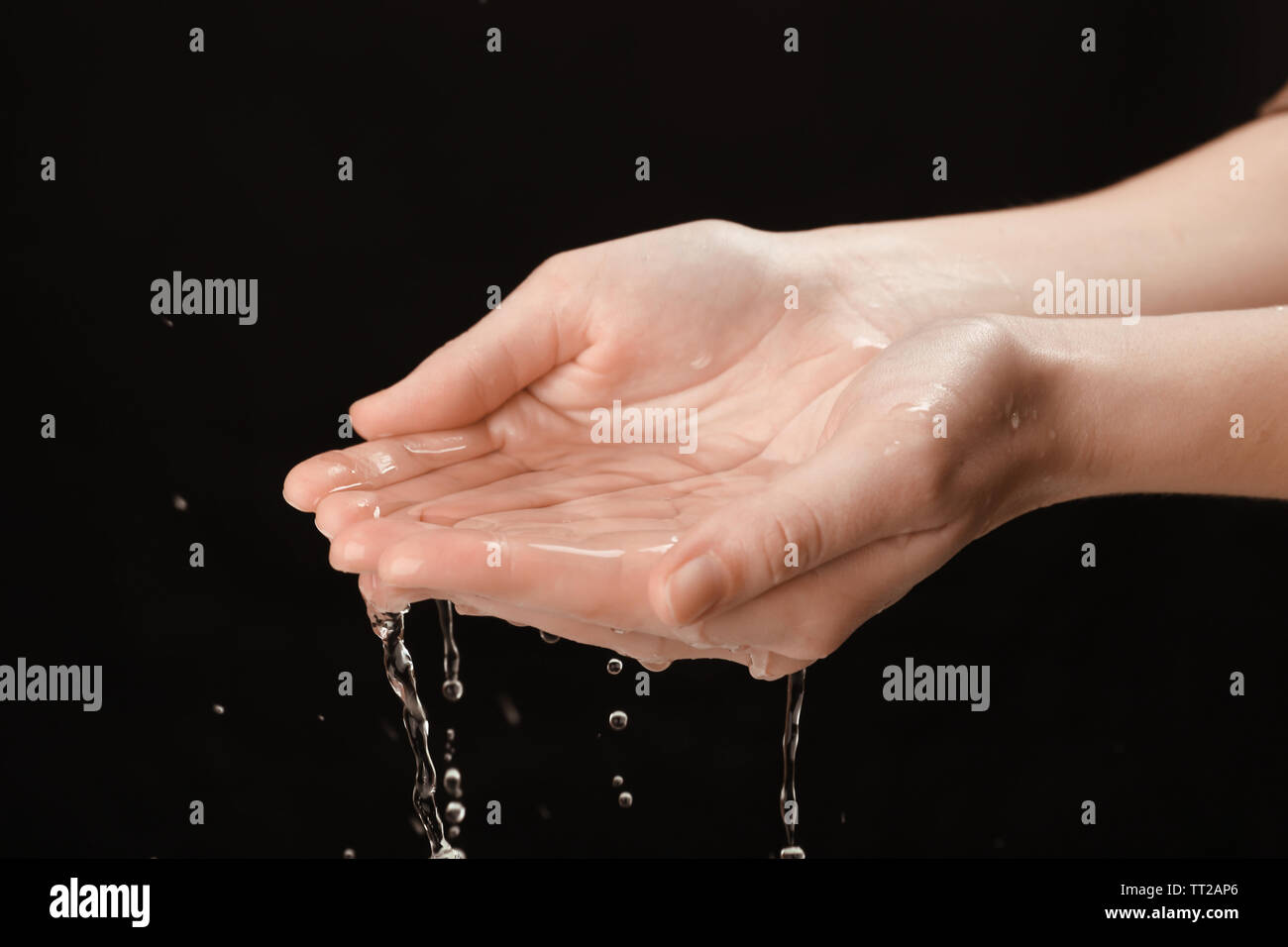 Human hands with water splashing on them on black background Stock ...