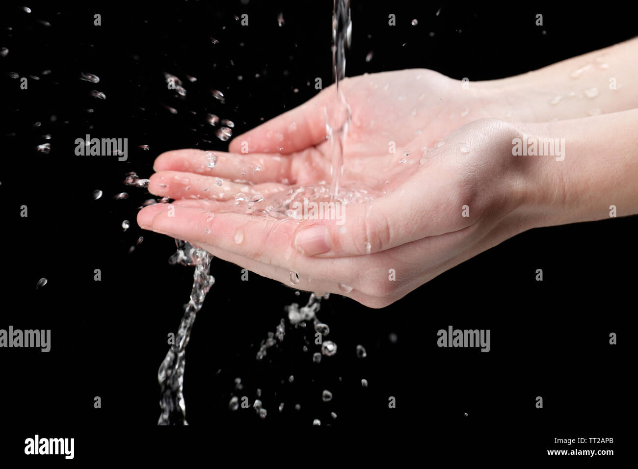 Human hands with water splashing on them on black background Stock ...