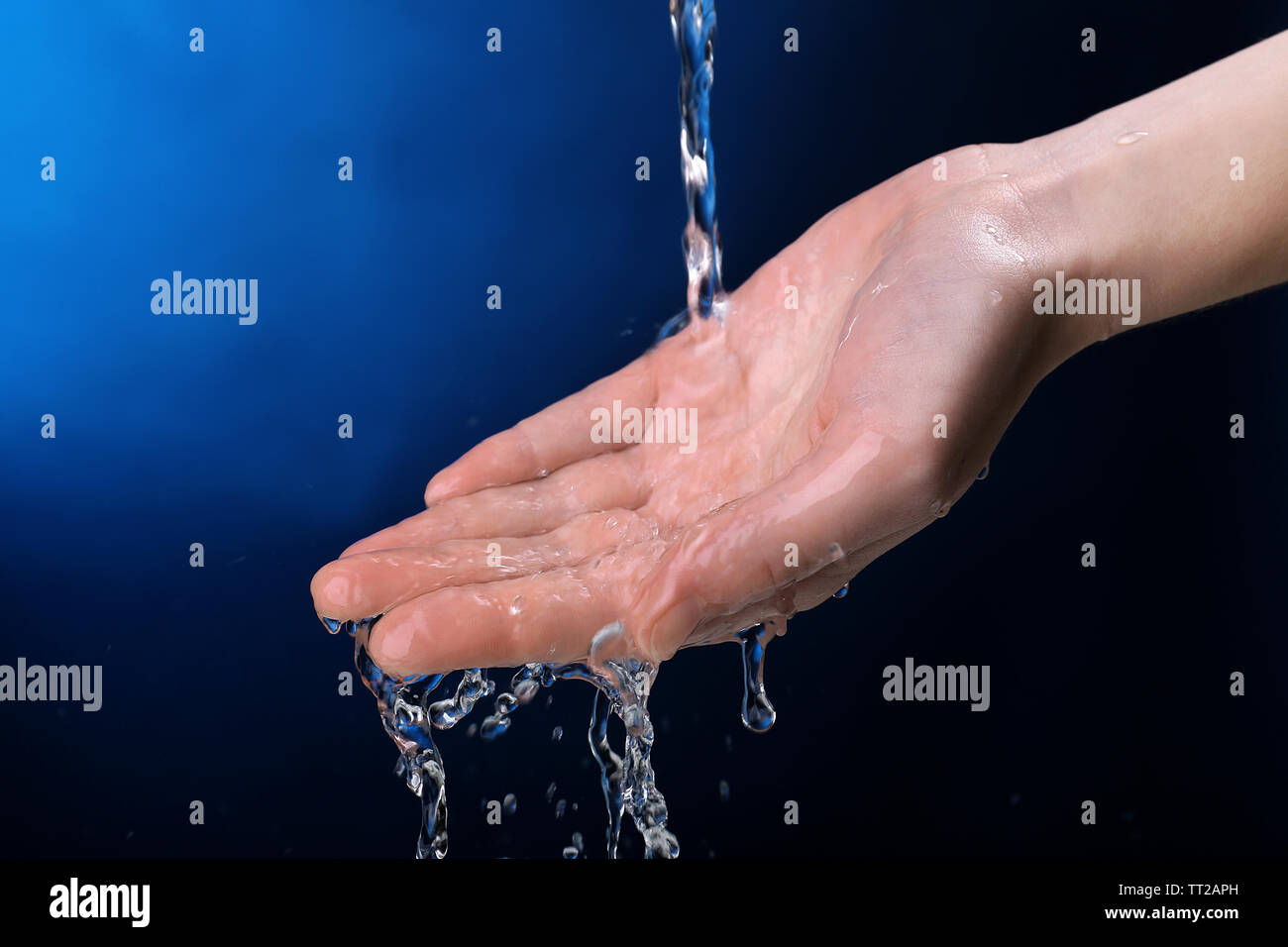 Human hand with water splashing on them on dark blue background Stock ...