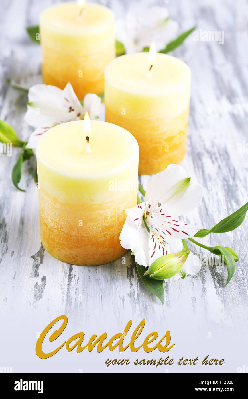 Beautiful candles with flowers on wooden background Stock Photo - Alamy