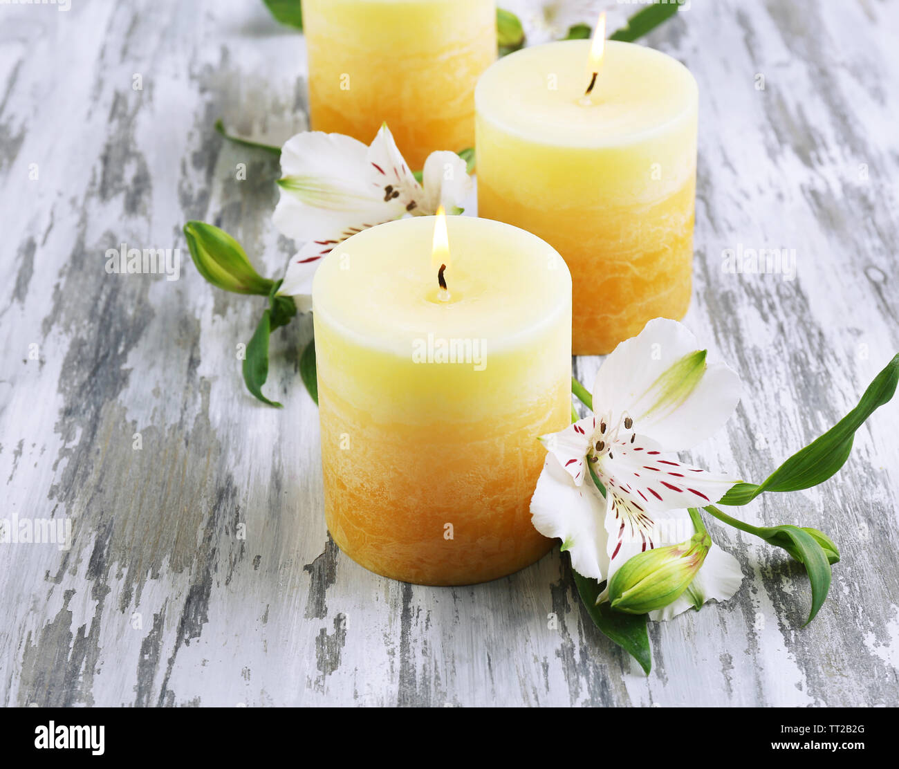 Beautiful candles with flowers on wooden background Stock Photo - Alamy
