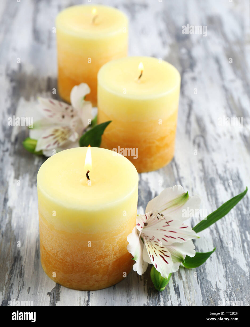 Beautiful candles with flowers on wooden background Stock Photo - Alamy