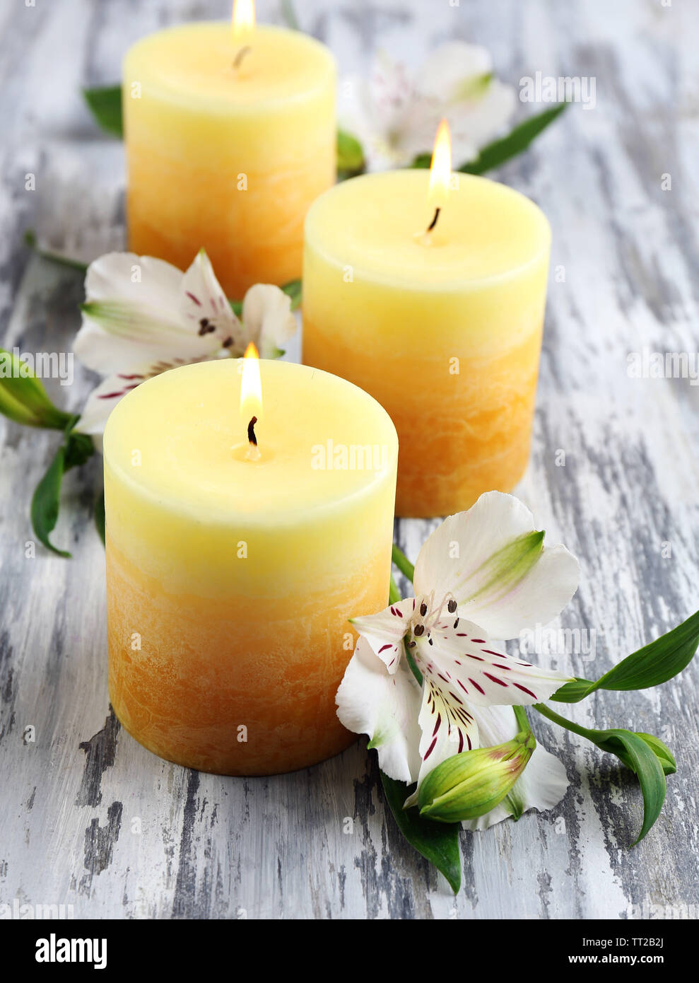 Beautiful candles with flowers on wooden background Stock Photo - Alamy