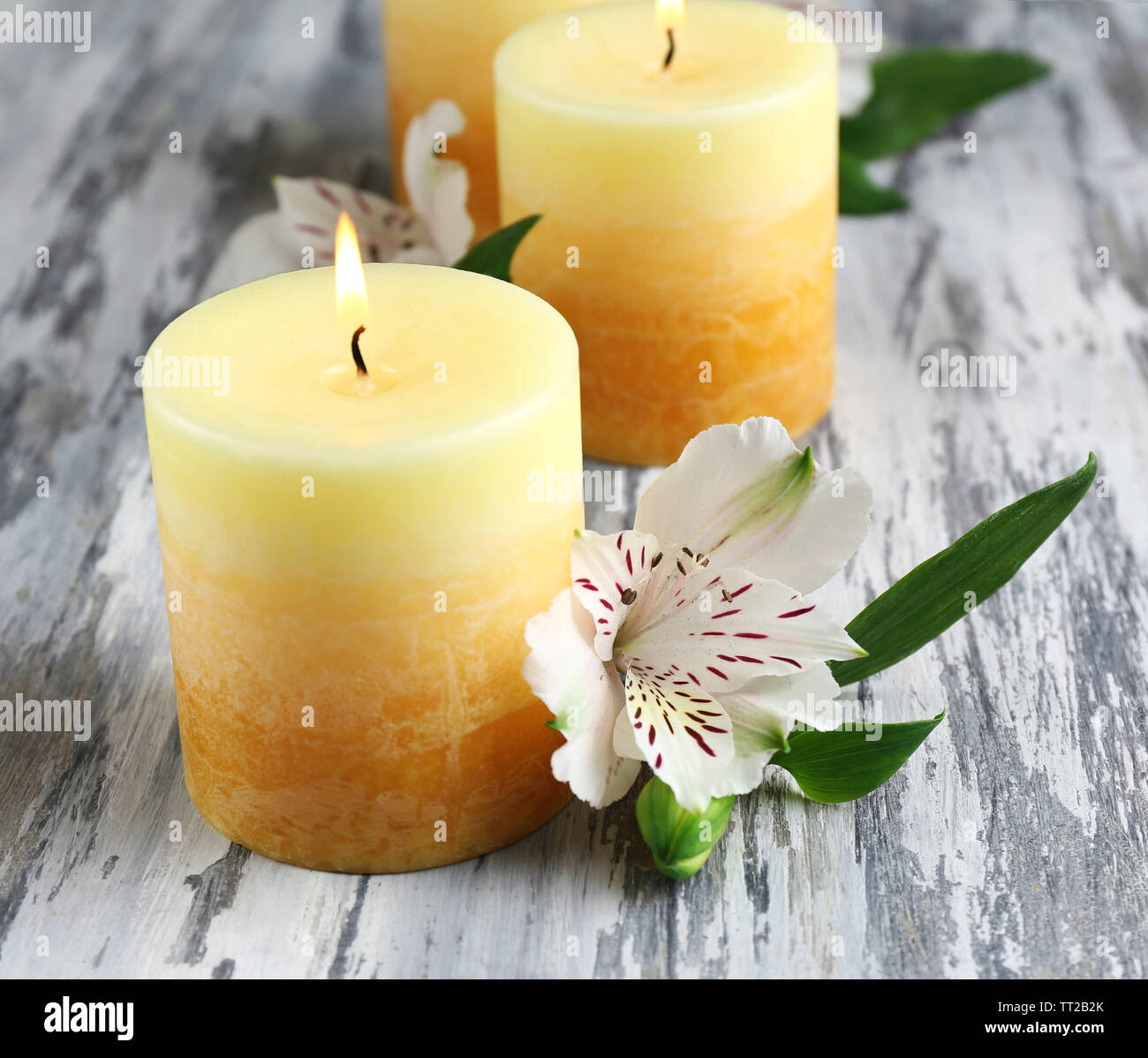 Beautiful candles with flowers on wooden background Stock Photo - Alamy