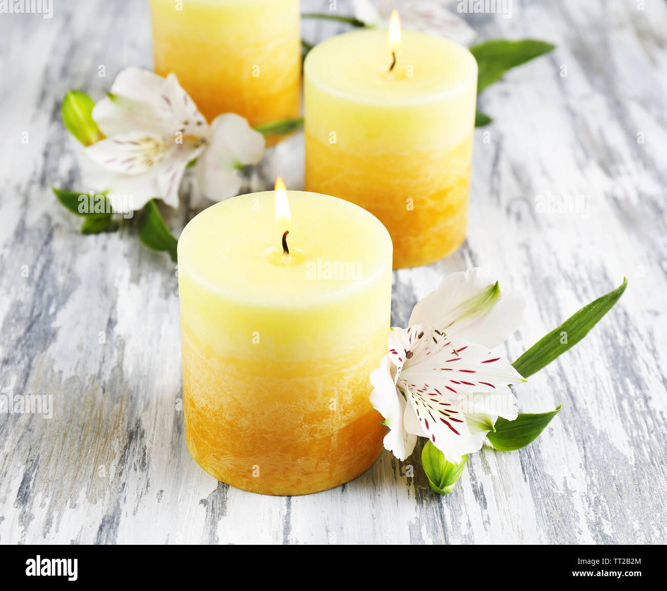 Beautiful candles with flowers on wooden background Stock Photo - Alamy