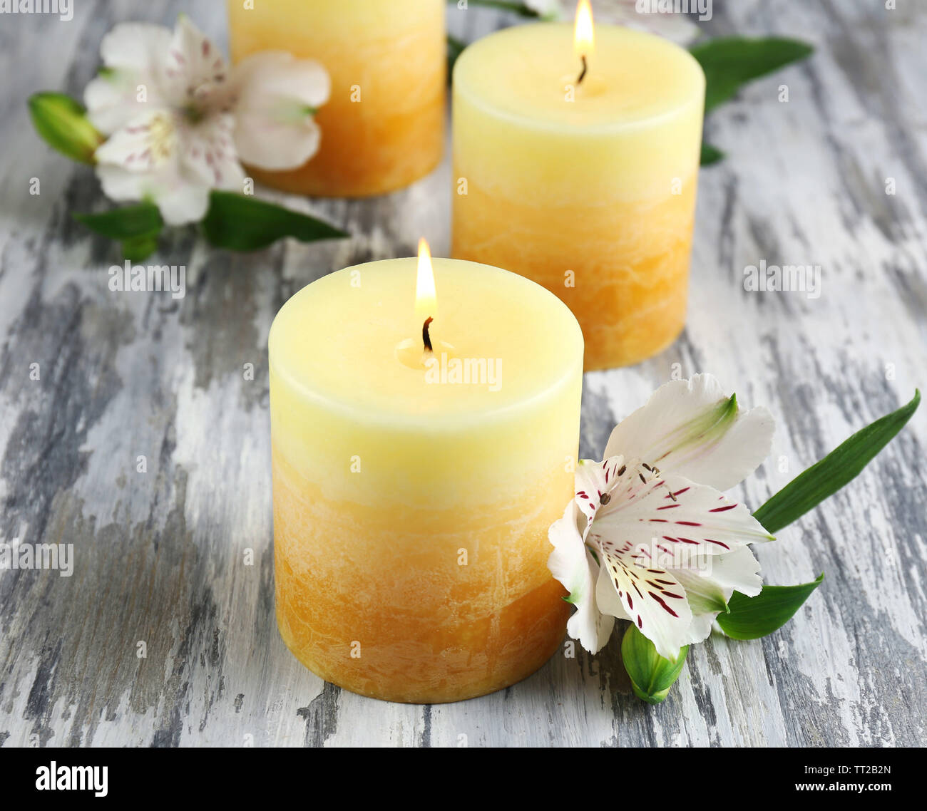 Beautiful candles with flowers on wooden background Stock Photo - Alamy