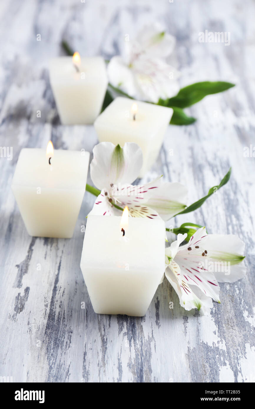Beautiful candles with flowers on wooden background Stock Photo - Alamy