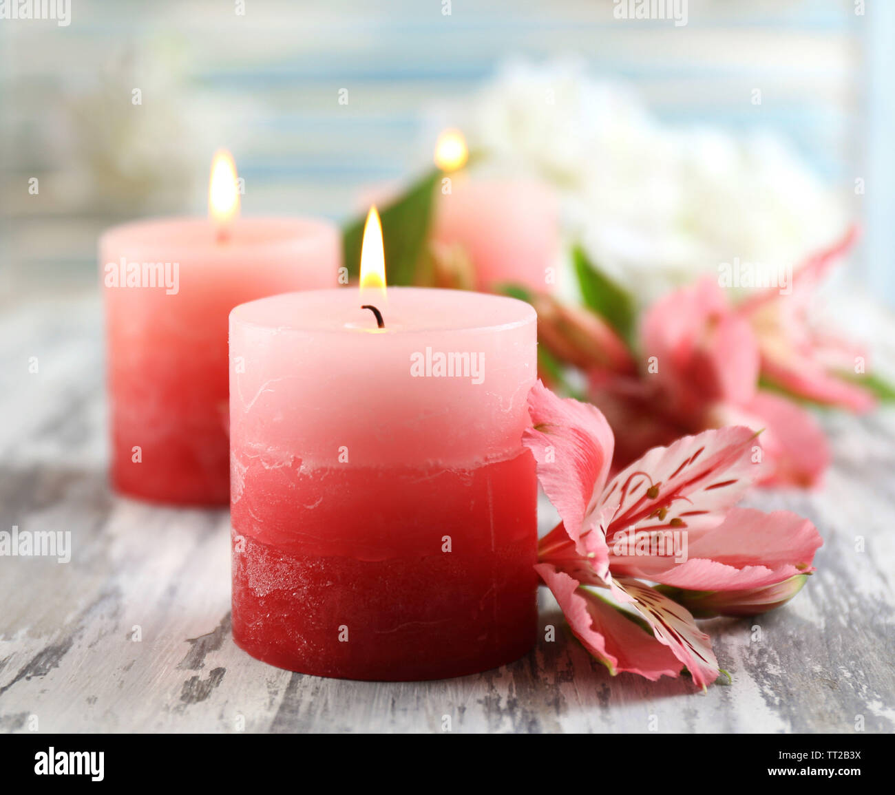 Beautiful candles with flowers on wooden background Stock Photo - Alamy