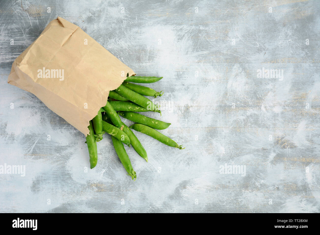 Fresh from the garden organic English peas in brown paper bag on rustic ...