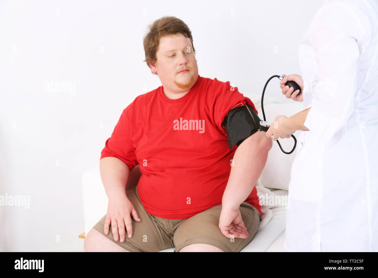 Doctor examining patient obesity on light background Stock Photo - Alamy