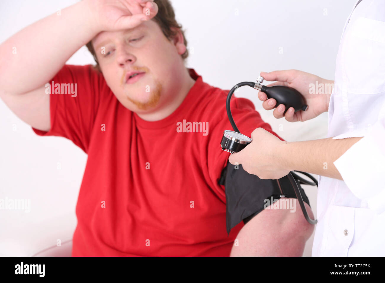 Doctor examining patient obesity on light background Stock Photo - Alamy