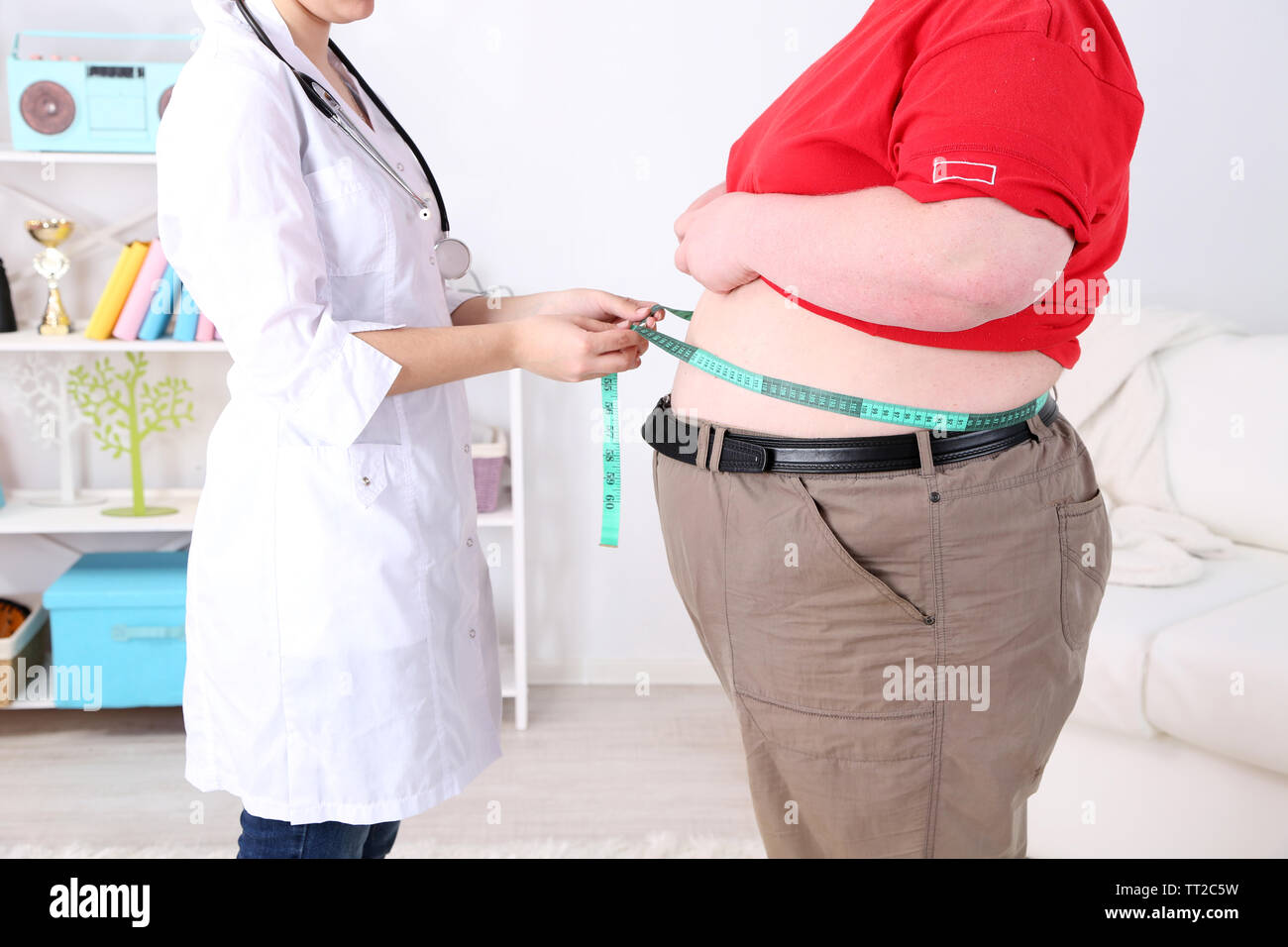 Doctor examining patient obesity on light background Stock Photo - Alamy