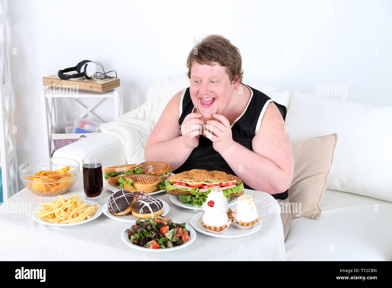 Fat man has a big lunch, on home interior background Stock Photo - Alamy