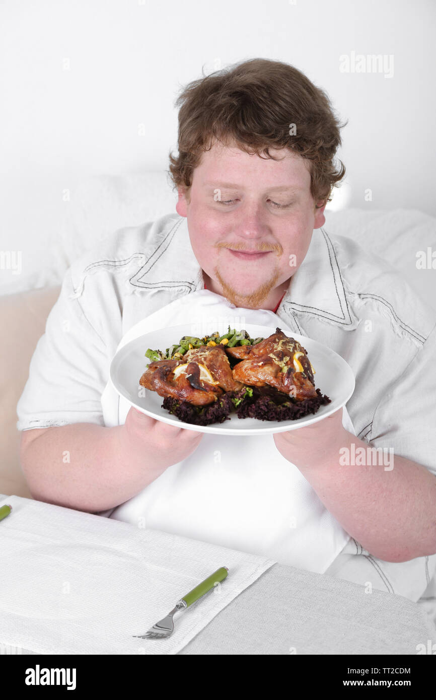 Tasty lunch for fat man, on home interior background Stock Photo - Alamy