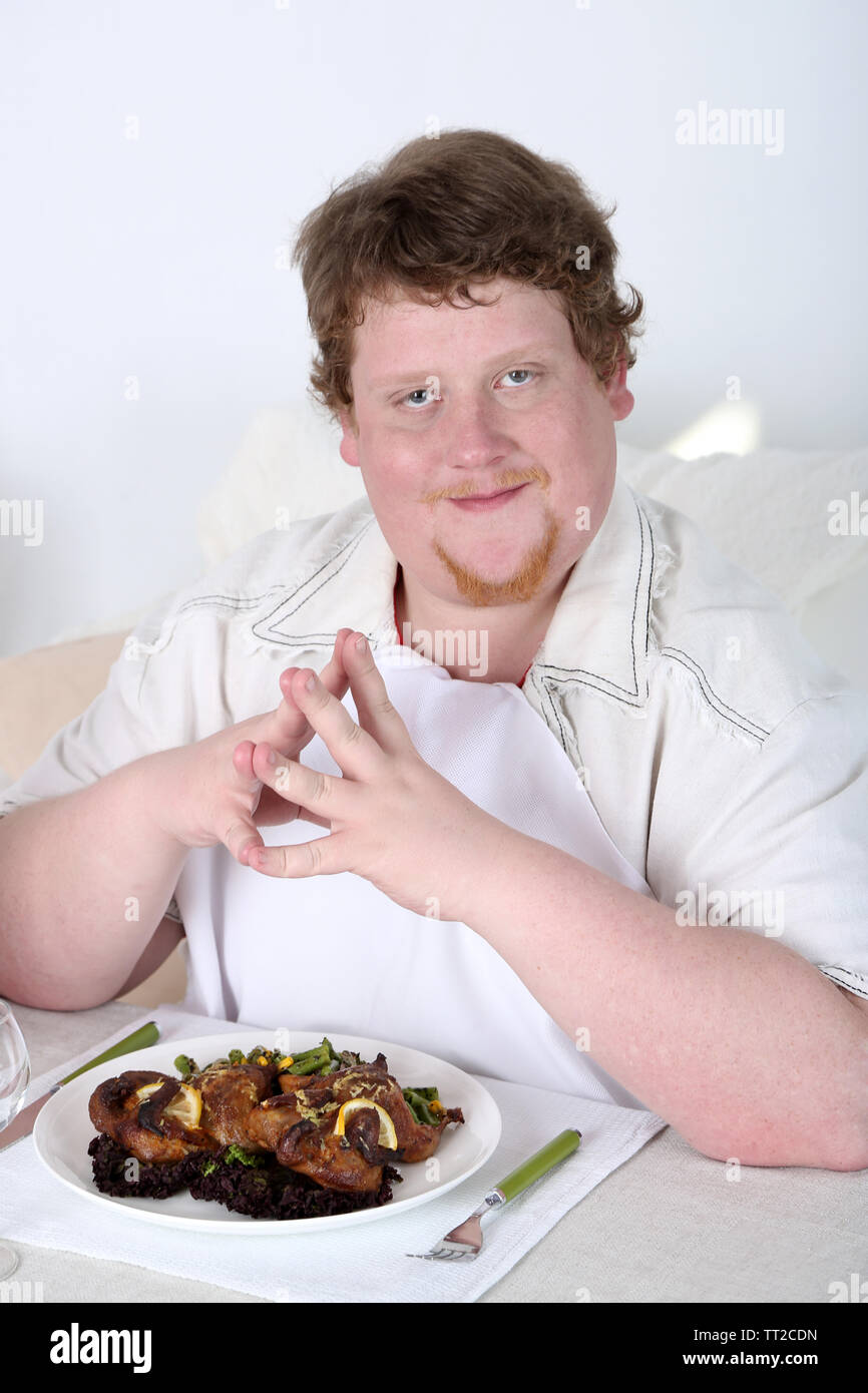 Tasty lunch for fat man, on home interior background Stock Photo - Alamy