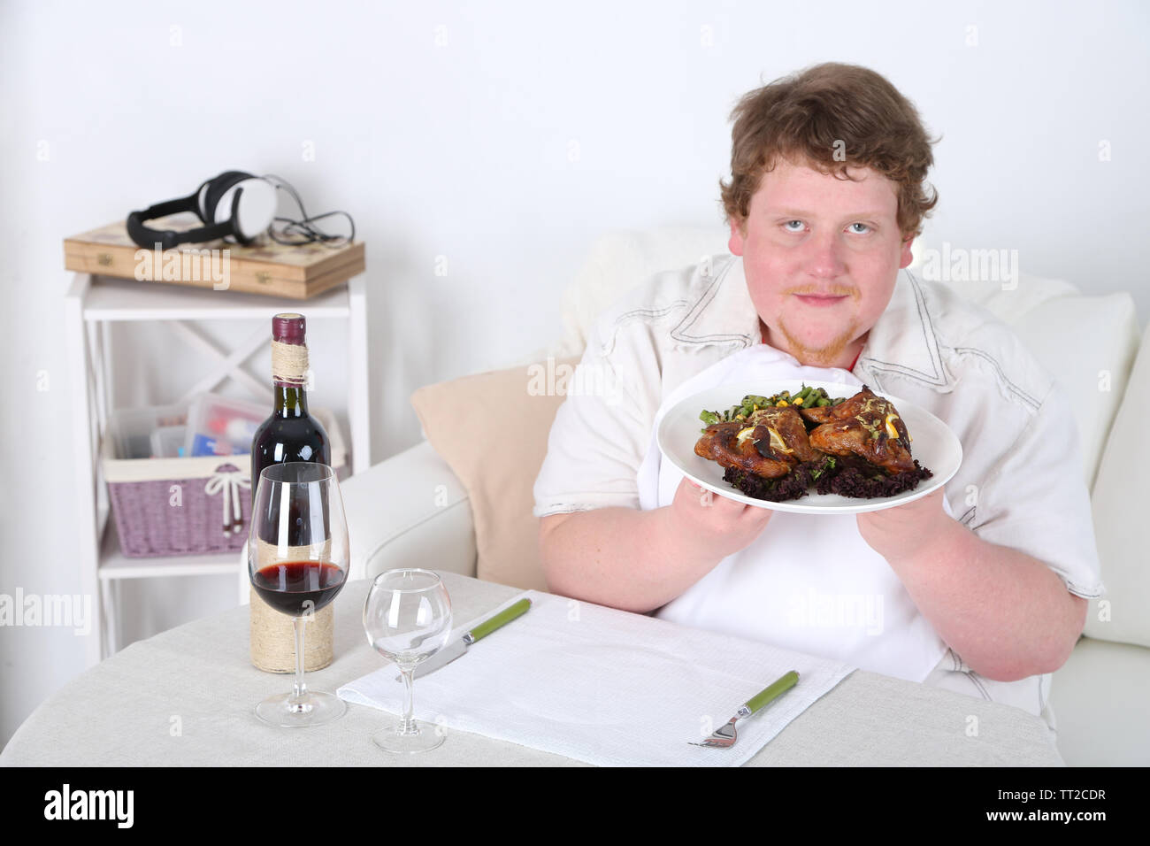 Tasty lunch for fat man, on home interior background Stock Photo - Alamy