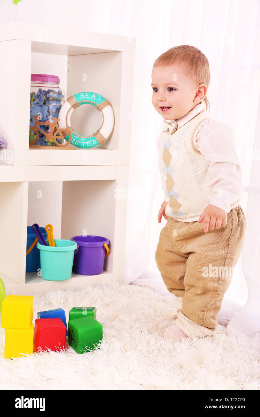 Cute little boy with color cubes in room Stock Photo - Alamy